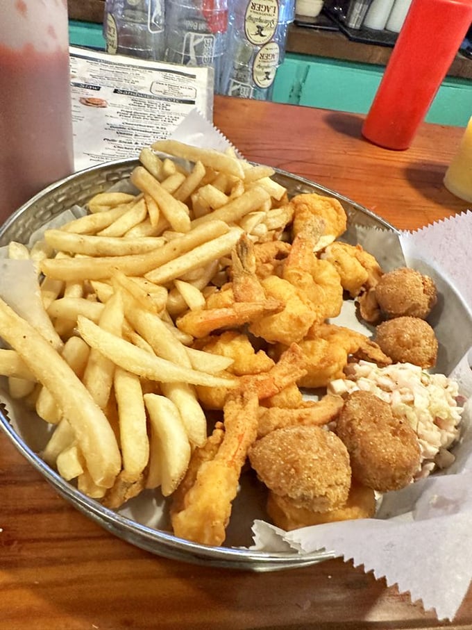 The holy trinity of coastal dining: golden shrimp, crispy hushpuppies, and fries that deserve their own fan club. Diet starts tomorrow.