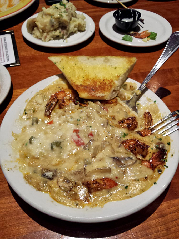 The shrimp and gouda grits arrive with a triangle of garlic bread standing at attention, ready for its noble purpose of sauce-sopping.