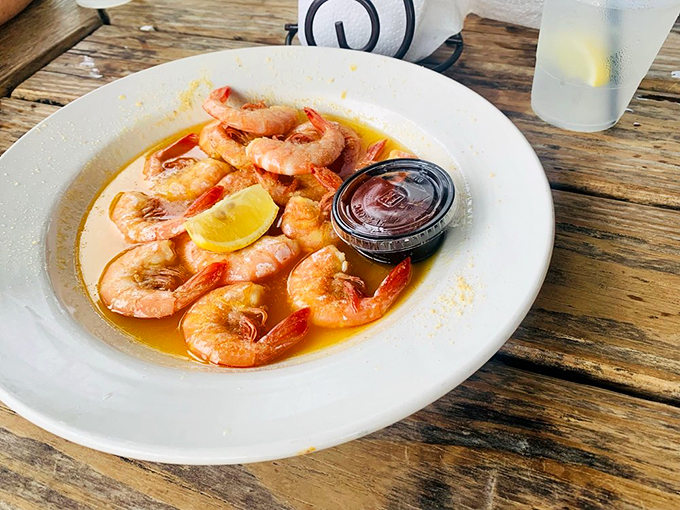 Peel-and-eat shrimp swimming in butter sauce—nature's perfect finger food served with a slice of lemon and zero pretension.