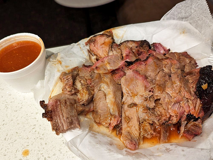 This sliced pork has that telltale pink smoke ring that separates the BBQ masters from the pretenders. That vinegar-based sauce is liquid gold.