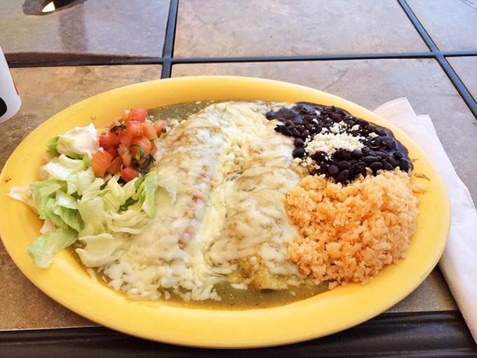 These enchiladas verdes don't just sit on the plate—they command attention with their vibrant sauce, melted cheese, and perfect proportions of rice and beans.