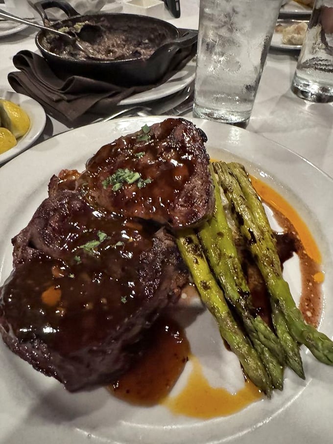 This isn't just a steak; it's a masterpiece with asparagus backup dancers. The glaze catches light like stained glass in a carnivore's cathedral.