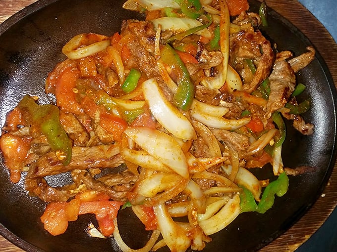 Sizzling fajitas that announce their arrival before you see them, a symphony of caramelized onions, peppers, and perfectly seasoned steak performing on a cast-iron stage.