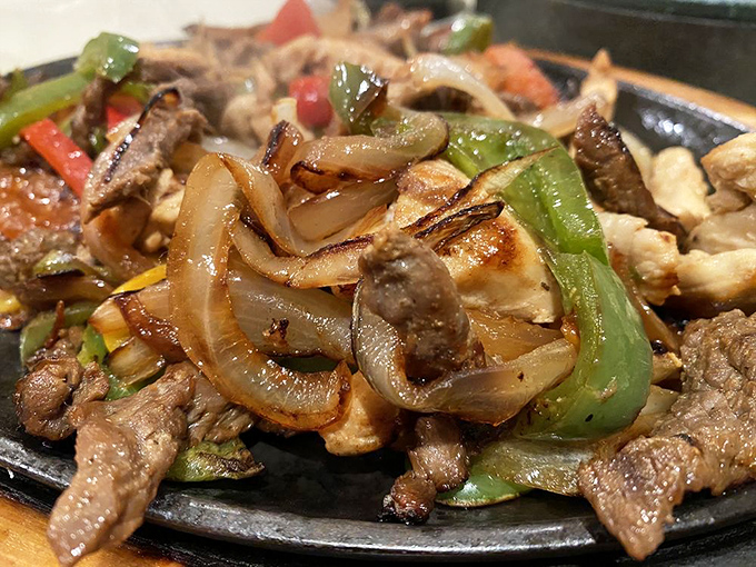 Sizzling fajitas that announce their arrival before you see them. These caramelized onions and peppers with steak and chicken are the dinner bell you can taste.