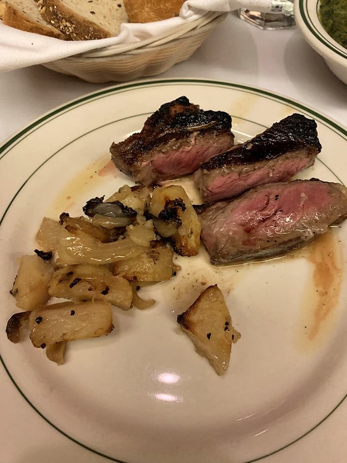 Steak sliced to showcase that perfect medium-rare glow, alongside home fries that have achieved the crispy-outside, tender-inside nirvana all potatoes aspire to.