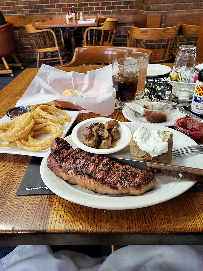 A complete midwestern feast: steak with perfect grill marks, mushrooms saut&eacute;ed to umami perfection, and a loaded baked potato that's practically a meal itself.