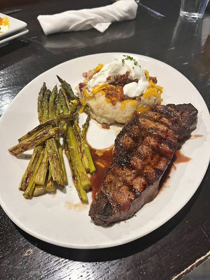 This plate is the holy trinity of steakhouse perfection&mdash;beautifully seared beef, grilled asparagus that still has dignity, and potatoes that didn't die in vain.