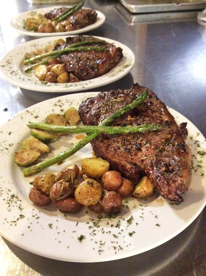Three perfectly seared steaks lined up like culinary soldiers, each accompanied by roasted potatoes and asparagus spears standing at attention.