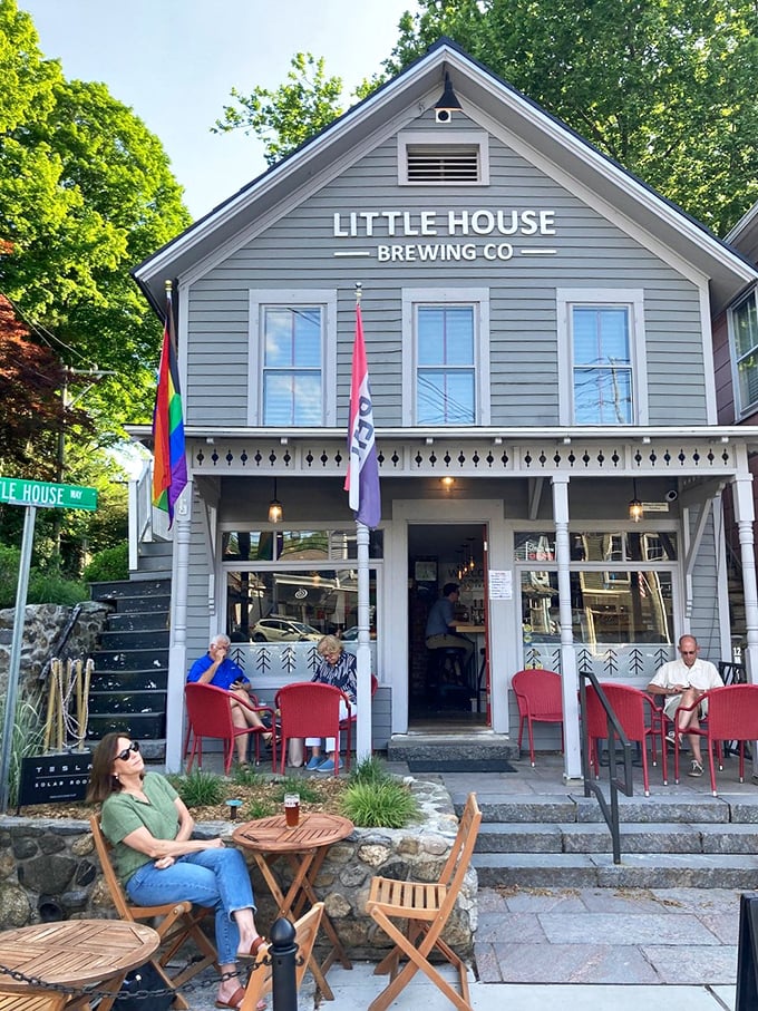 Inviting red chairs and a gray gabled building offer you a relaxing spot to enjoy a cold local craft beer.