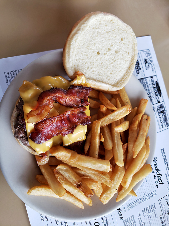 This isn't just a bacon cheeseburger &ndash; it's edible therapy on a plate, where crispy fries stand guard around a masterpiece of American comfort. 