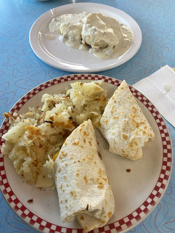 Breakfast burritos done right—golden-grilled tortilla wrapping a treasure trove of fillings, flanked by potatoes that have achieved the perfect crisp-tender balance.