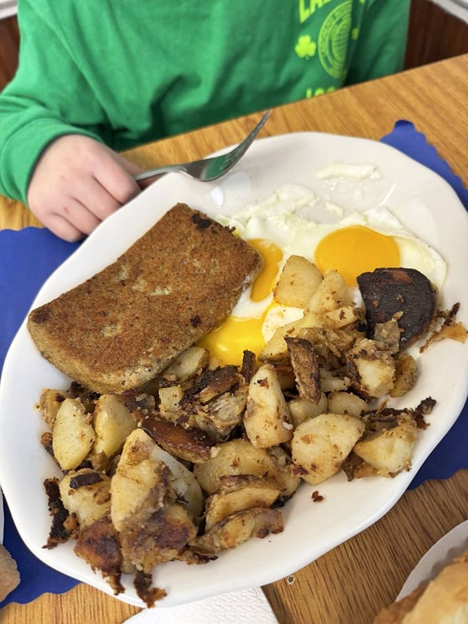 Sunny-side up eggs with a mountain of home fries that could convert any breakfast skeptic. The toast? Just waiting for its butter bath.