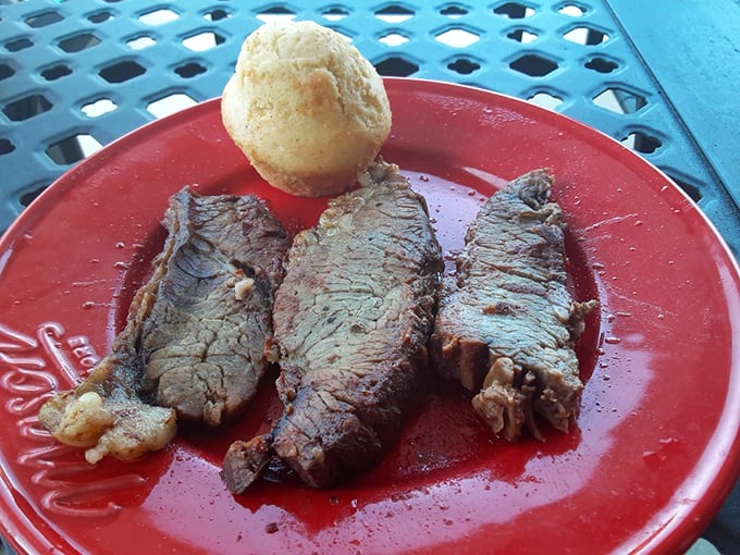 Three slices of brisket and a cornbread muffin on a red plate&mdash;a simple presentation that lets the star of the show take center stage without unnecessary distractions.