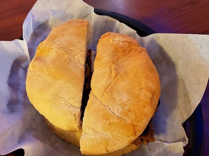 The perfect burger cross-section reveals the truth: a golden-brown bun embracing a substantial patty that's been kissed by a well-seasoned flat-top grill.