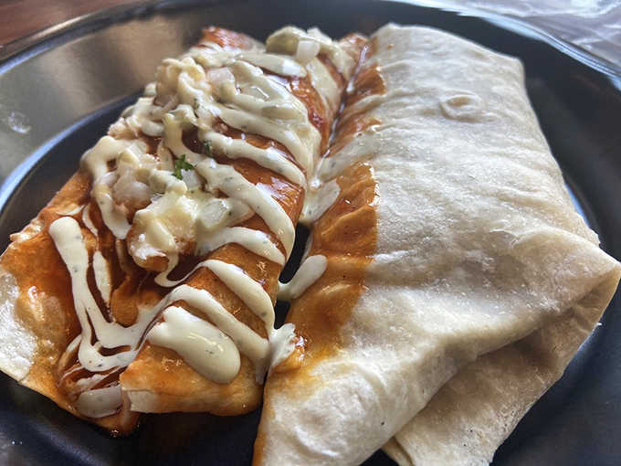 Half burrito, half enchilada, 100% reason to loosen your belt. That drizzle of sauce is like the autograph of a culinary artist.