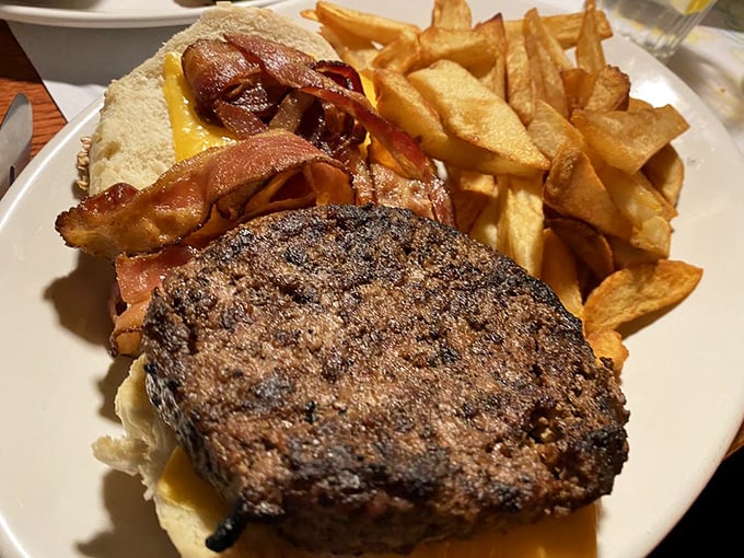The holy trinity of diner perfection: a juicy burger, crispy bacon, and hand-cut fries that could make a Frenchman weep with joy.