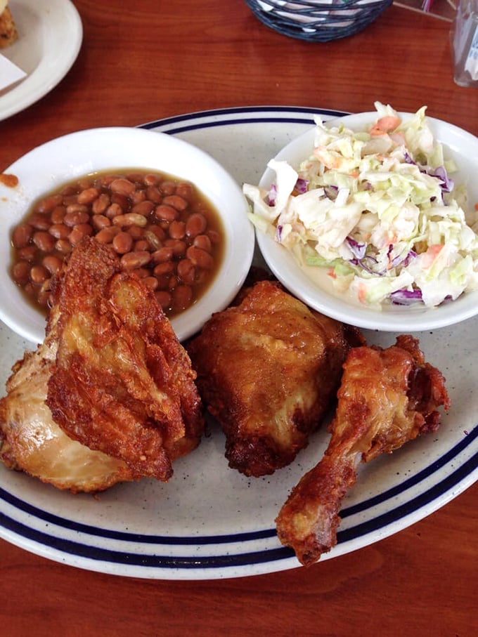 The holy trinity of comfort food: crispy fried chicken, hearty baked beans, and fresh coleslaw. Napkins required, regrets impossible.