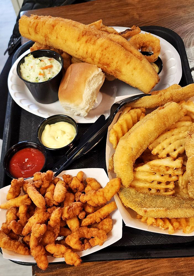 The fish and chips platter that launched a thousand road trips. That perfect golden batter shatters with each bite, revealing tender fish that tastes like vacation.