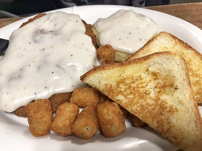 That white pepper gravy cascading over golden-fried steak is the kind of simple perfection that makes you question why anyone bothered inventing fancy cuisine.