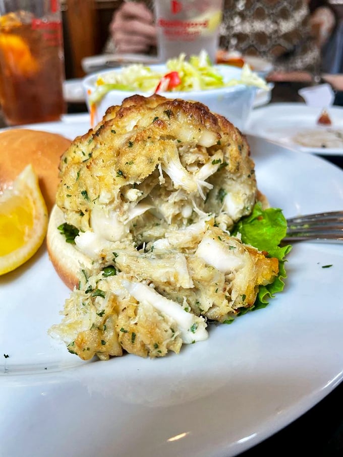 The cross-section reveals the truth: pure, sweet jumbo lump crab meat with barely enough binding to maintain structural integrity. This is seafood architecture at its finest.