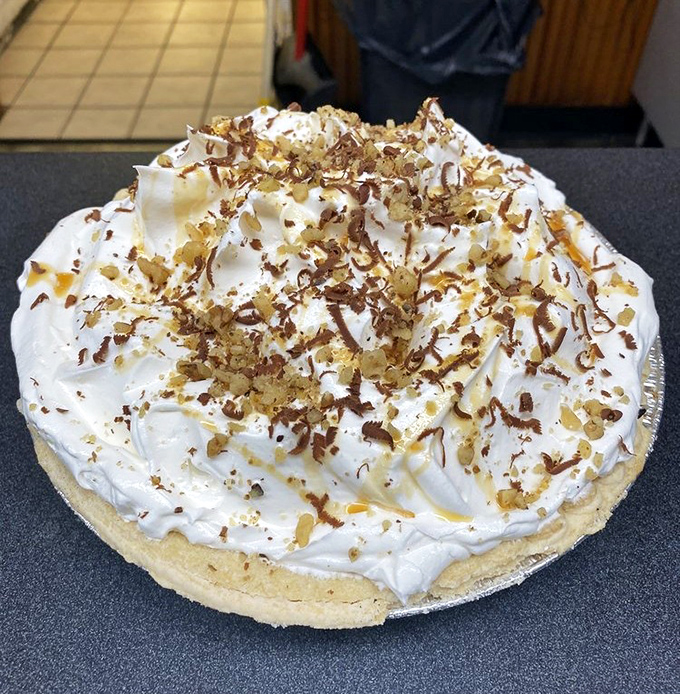 A coconut cream masterpiece crowned with toasted coconut flakes. The mountain of whipped cream isn't just showing off—it's an essential architectural element.