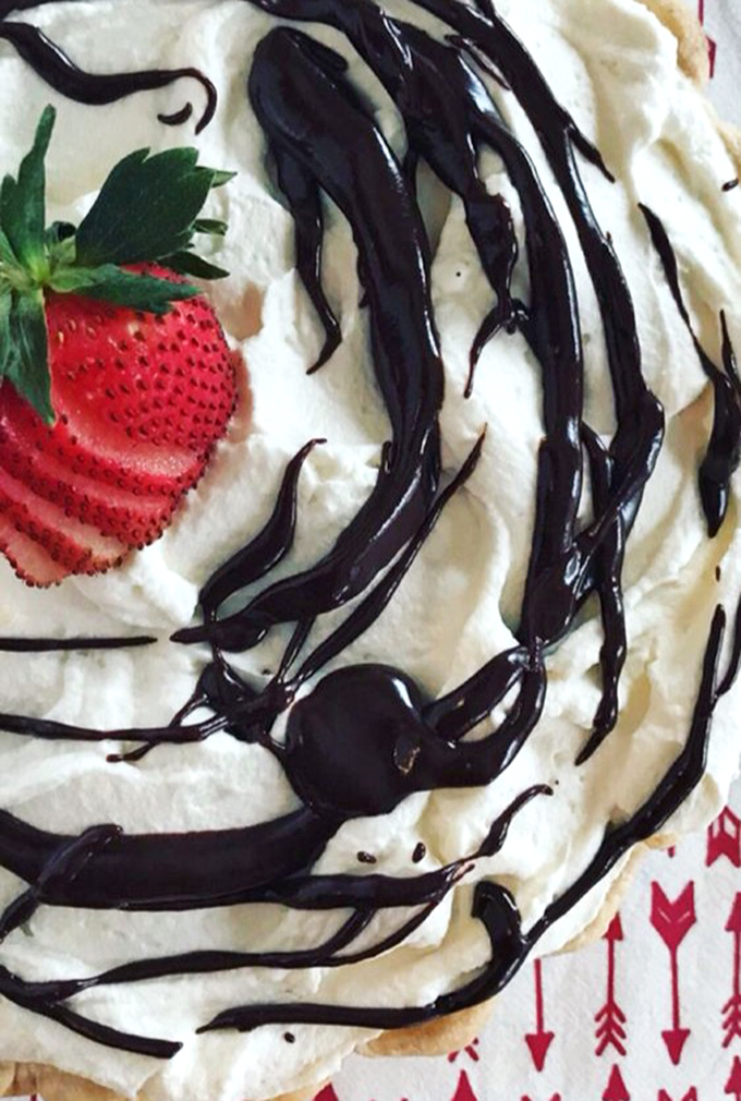 Chocolate drizzle dancing across whipped cream with a strawberry garnish. This isn't just dessert—it's what clouds must taste like in heaven's VIP section.