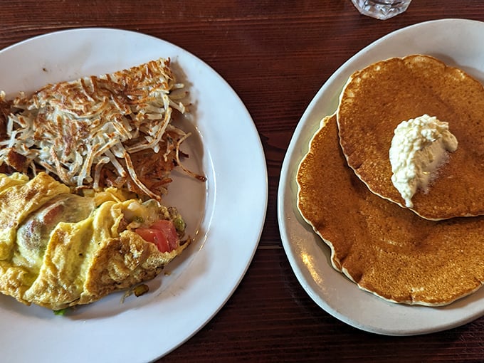 Breakfast nirvana: golden pancakes and a veggie-packed omelet sharing the spotlight. The hash browns are staging a delicious rebellion on the side.