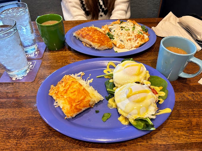 Eggs Benedict done right: perfectly poached eggs perched atop spinach, drizzled with hollandaise that cascades like a buttery waterfall.