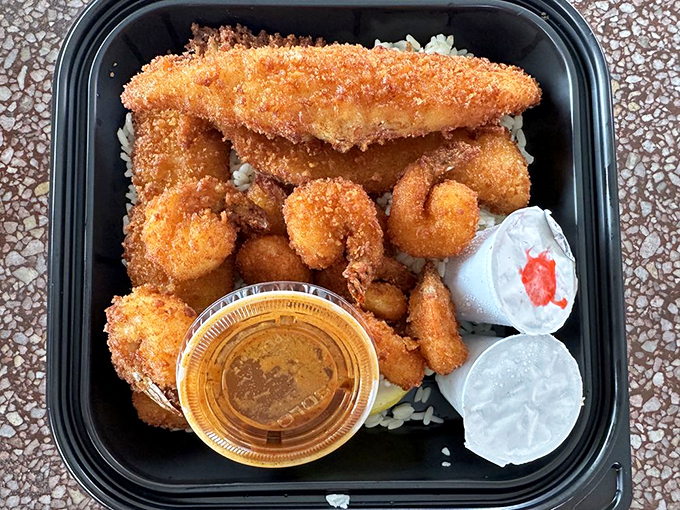A seafood feast fit for royalty, served in a humble black container. The contrast between simple packaging and sublime flavor is pure LA magic.