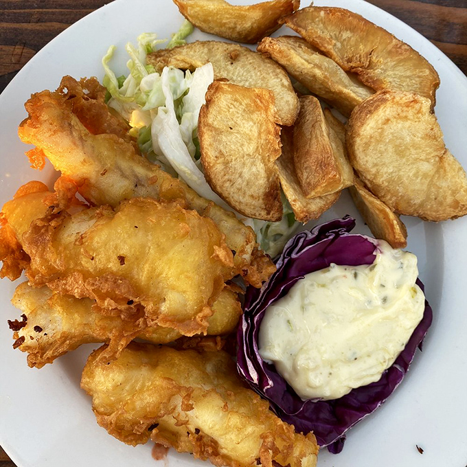 The holy trinity of seafood dining: crispy batter, flaky white fish, and thick-cut chips. Add tartar sauce and you've got a religious experience.