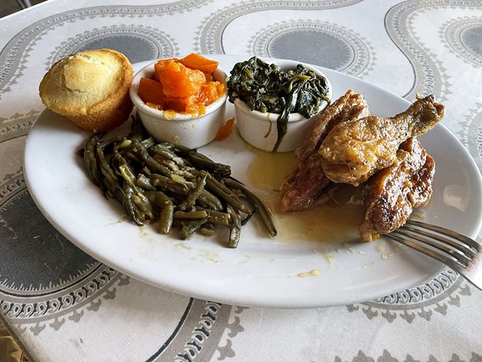 Soul food symphony on a plate: green beans, candied yams, collard greens, and fried chicken playing together in perfect harmony.