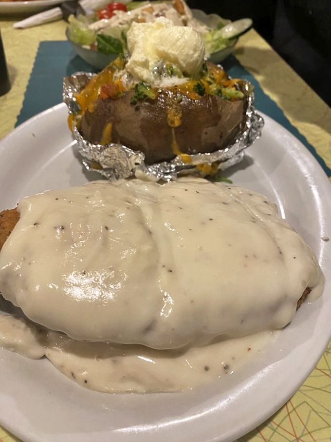 This isn't just country fried steak&mdash;it's edible therapy. The crispy coating and velvety gravy create a comfort food masterpiece that pairs perfectly with that loaded potato.
