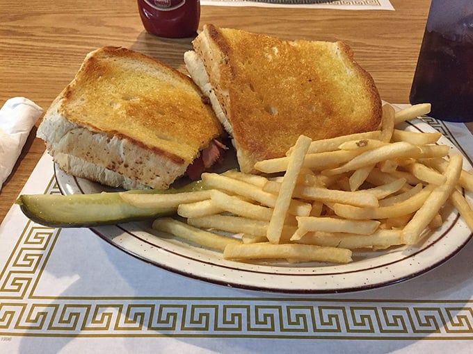 The humble grilled ham and cheese achieves perfection when paired with golden fries and a pickle spear&mdash;proof that simplicity often trumps complexity.