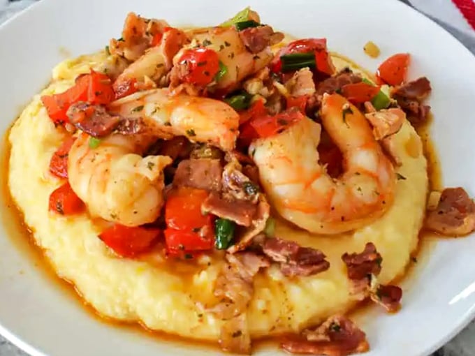A Southern classic reimagined&mdash;these grits cradle plump shrimp and bacon with the tenderness of a lullaby. Comfort food that graduated with honors.