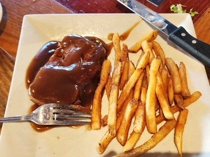 The meatloaf glistens under its blanket of rich gravy, while golden fries stand at attention nearby. This is the kind of meal that makes you forget your table manners.
