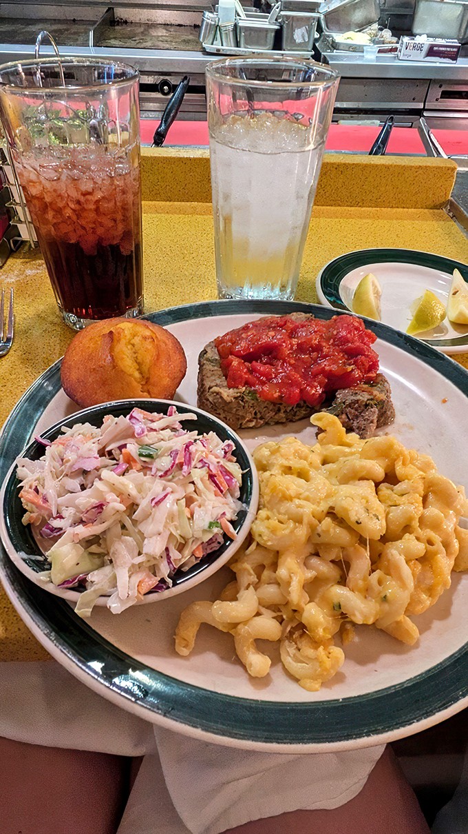 The meatloaf arrives like a celebrity on tour &ndash; flanked by creamy mac and cheese, fresh slaw, and a cornbread muffin that deserves its own fan club.