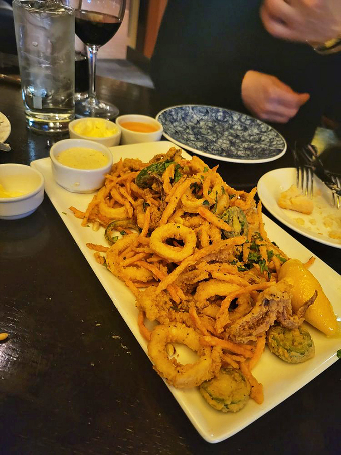 A mountain of fried goodness with dipping sauces standing by like eager assistants, ready to elevate each bite to new flavor heights.
