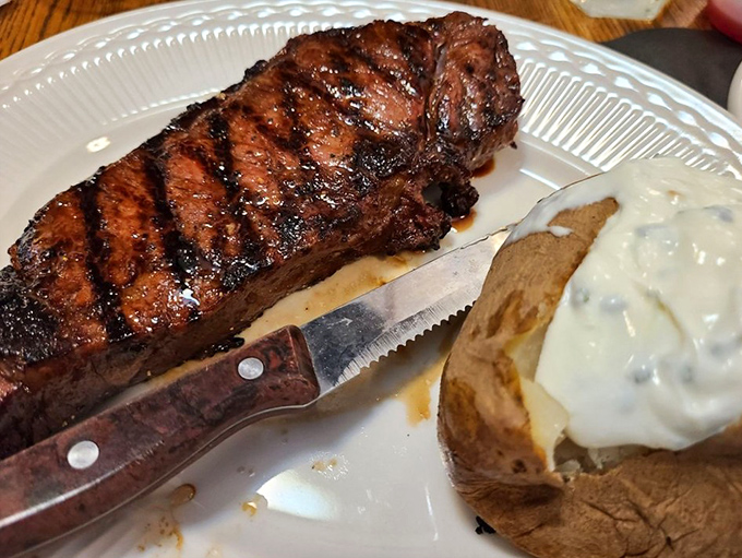 This NY Strip has more perfect grill marks than a 1950s TV dad has perfect advice. The knife stands ready for the joyful task ahead.