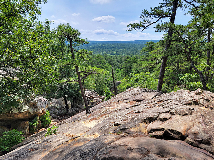 From atop the sandstone bluffs, the Kiamichi Mountains unfold in waves of green, a view that makes smartphone cameras seem woefully inadequate.
