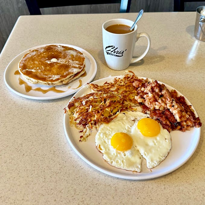 The holy trinity of breakfast: golden pancakes, sunny-side-up eggs, and crispy hash browns. A plate that says "Good morning" in the most delicious way.
