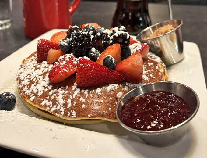 Pancake perfection that would make angels weep: Berries cascade over fluffy hotcakes dusted with powdered sugar, served with real maple syrup &ndash; not that impostor stuff.