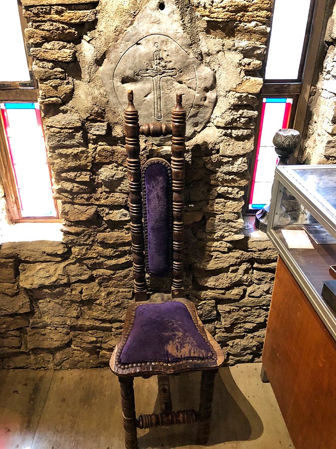 Not your average throne room setup&mdash;this handcrafted chair beneath a carved cross embodies the castle builder's dedication to both craftsmanship and spiritual values.