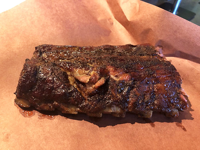 This isn't just a rack of ribs; it's a masterpiece of smoke and time, with a crust that whispers sweet nothings to your taste buds.