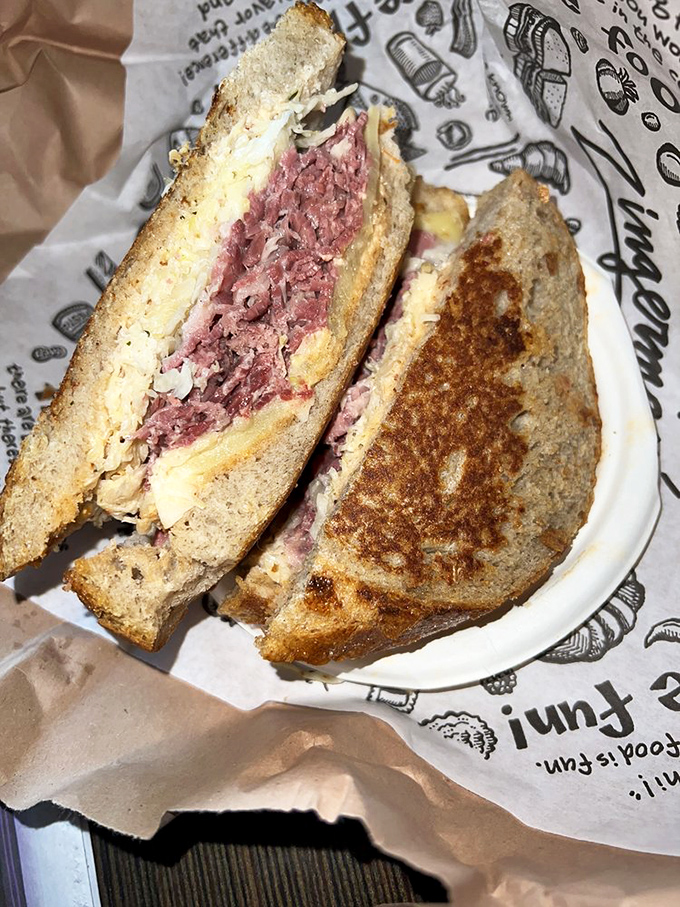The perfect Reuben cross-section reveals geological layers of deliciousness. Archaeologists of flavor would have a field day here.