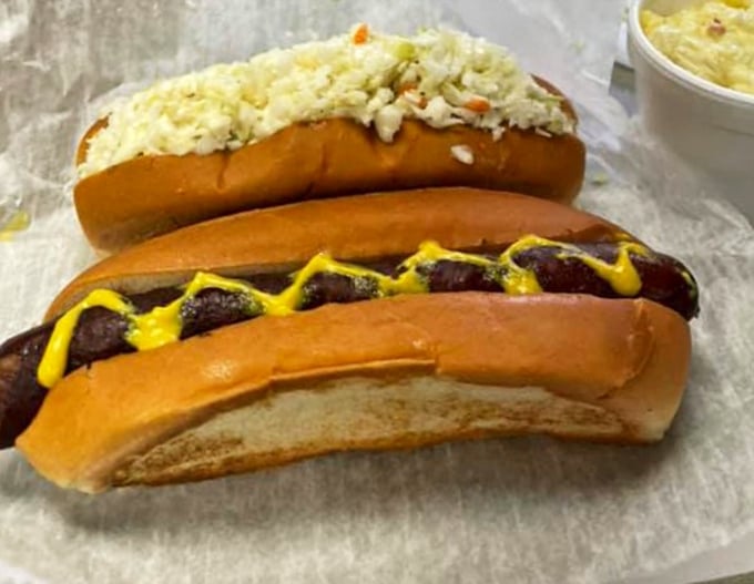 The classic lineup: one dressed in slaw's crisp finery, another flaunting mustard's golden touch. Hot dog diplomacy at its finest.