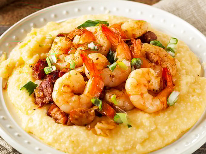 Plump shrimp nestled on golden grits like treasures on a sunlit beach&mdash;this isn't just food, it's edible poetry with a Southern drawl.