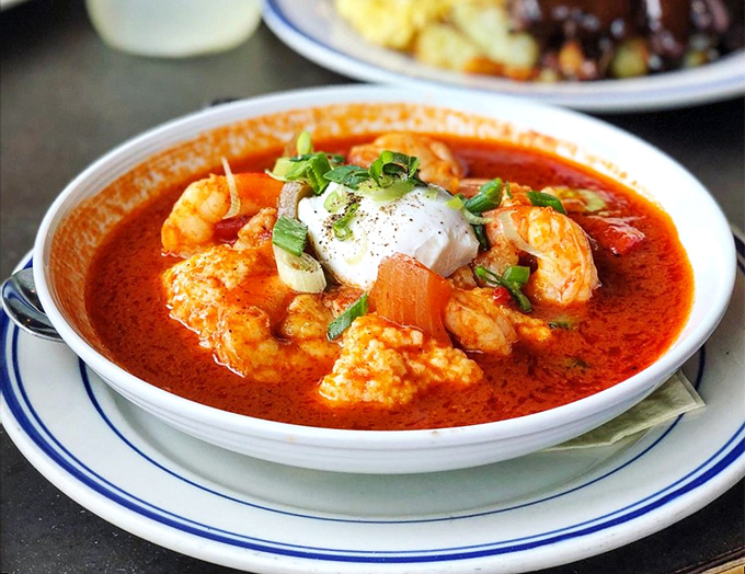 This isn't just shrimp and grits; it's a spicy, saucy celebration swimming in a vibrant tomato broth that demands to be sopped up with something bready.