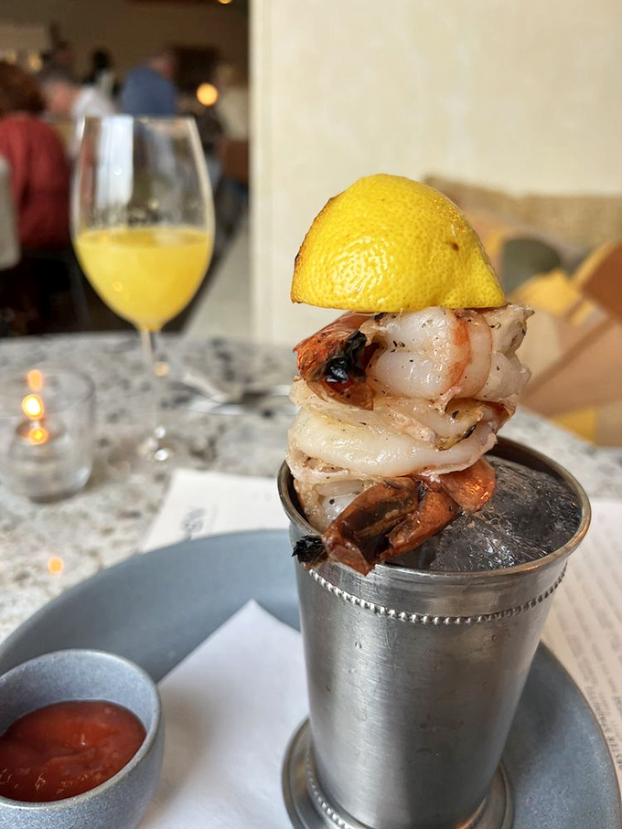Shrimp cocktail reimagined: these plump crustaceans perch on the edge of their silver chalice like divers contemplating the perfect plunge.