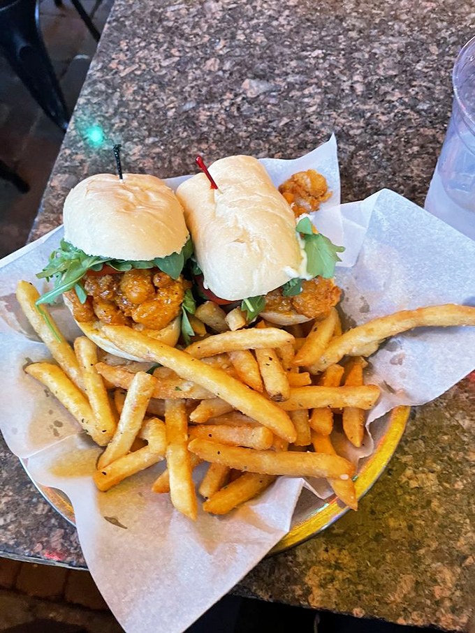 Golden-fried shrimp sliders nestled against crispy fries—a combination that proves sometimes life's greatest pleasures come on wax paper.