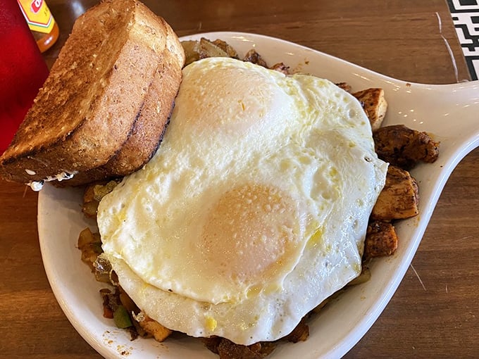 Sunny-side up eggs lounging atop a bed of perfectly seasoned home fries&mdash;like a breakfast postcard saying "Wish you were here eating this instead of that sad granola bar."